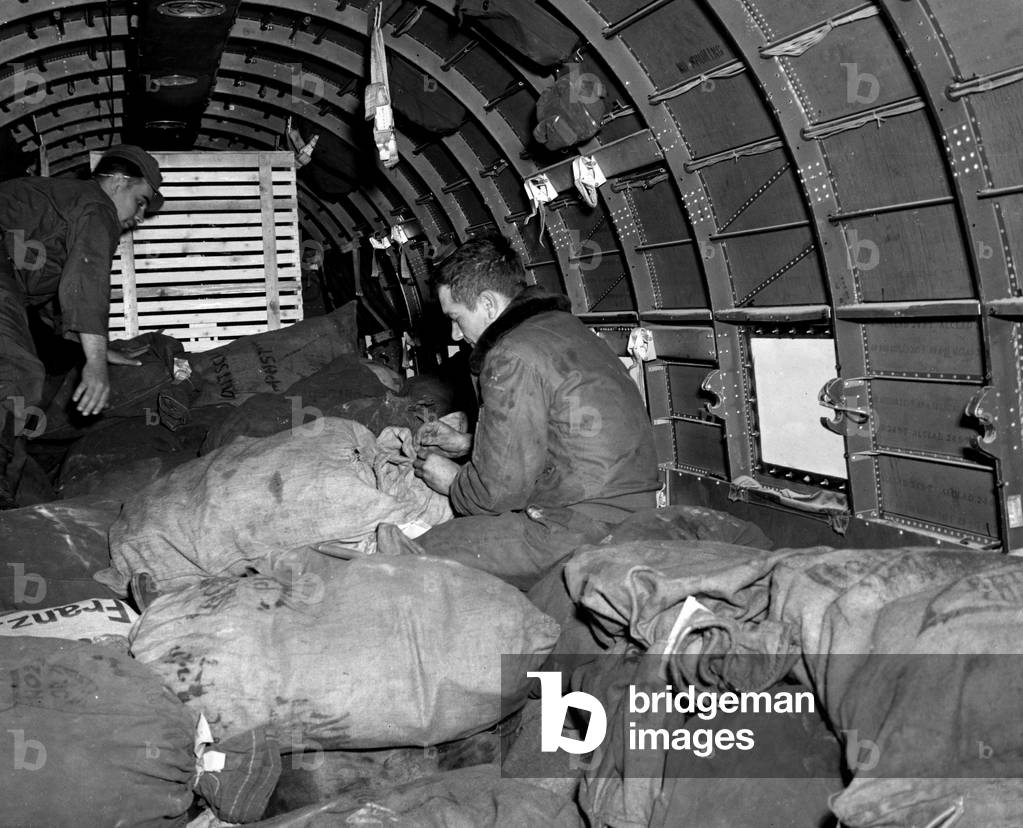 Image of Two GIs label the bags of three tons of mail,