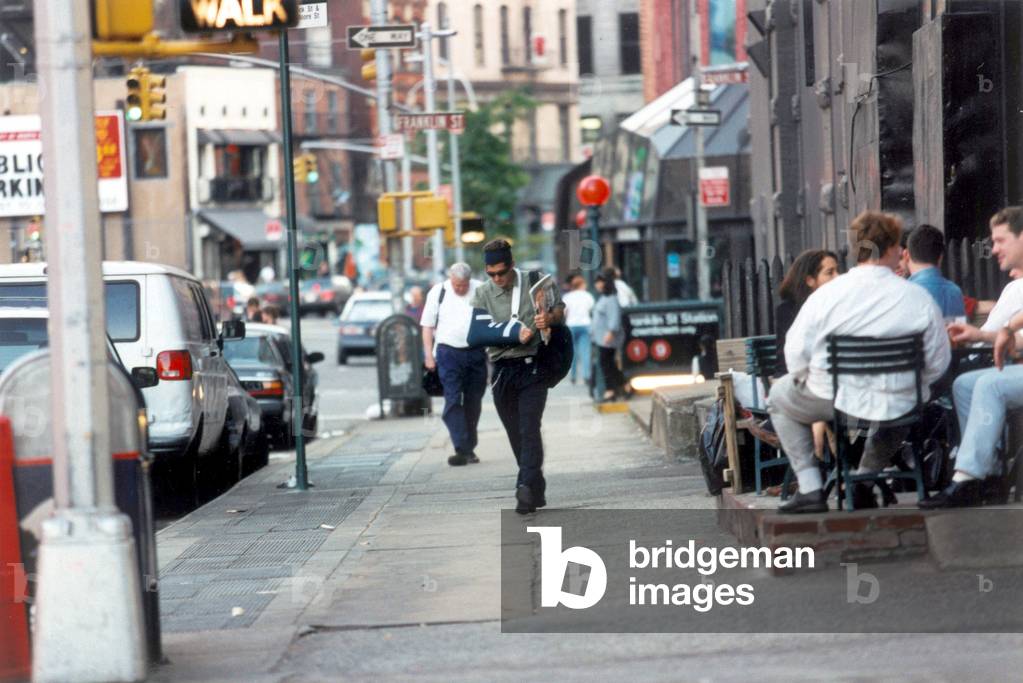 Image of John F. Kennedy Jr. (JFK Jr.) with cast on arm