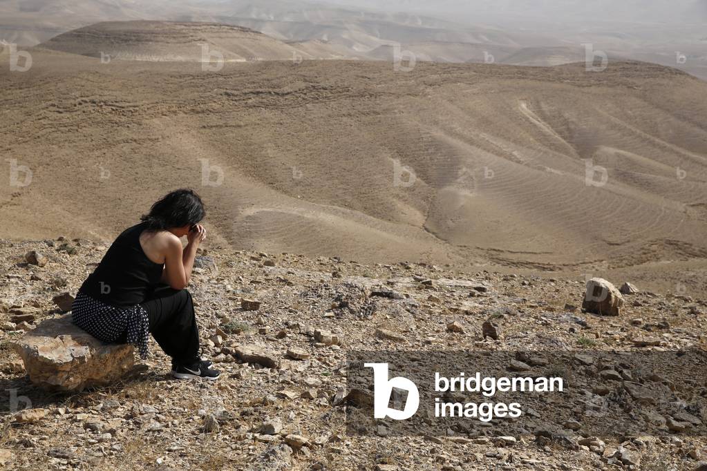 Image of Pilgrimage in Holy Land, Woman praying in Judean desert, Arad,