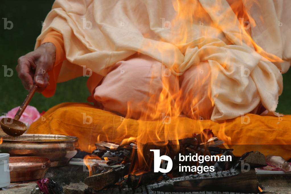 Image of Swami Veetamohanda performing the homa fire ritual in the garden