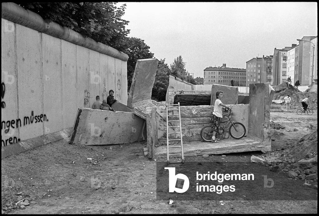 Image of Children playing amongst segments of the Berlin Wall, in the