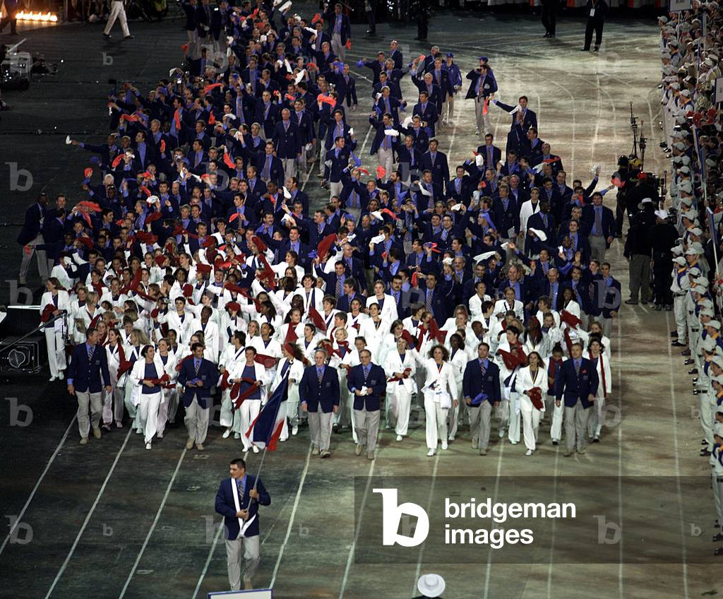Image of French flag bearer Daniel Douillet, the Judo gold medalist, leads