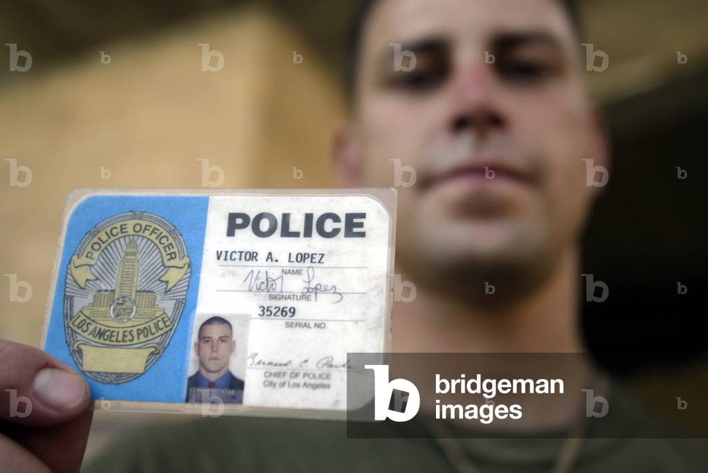 Image of LAPD OFFICER VICTOR LOPEZ DISPLAYS HIS ID CARD DURING JOINT