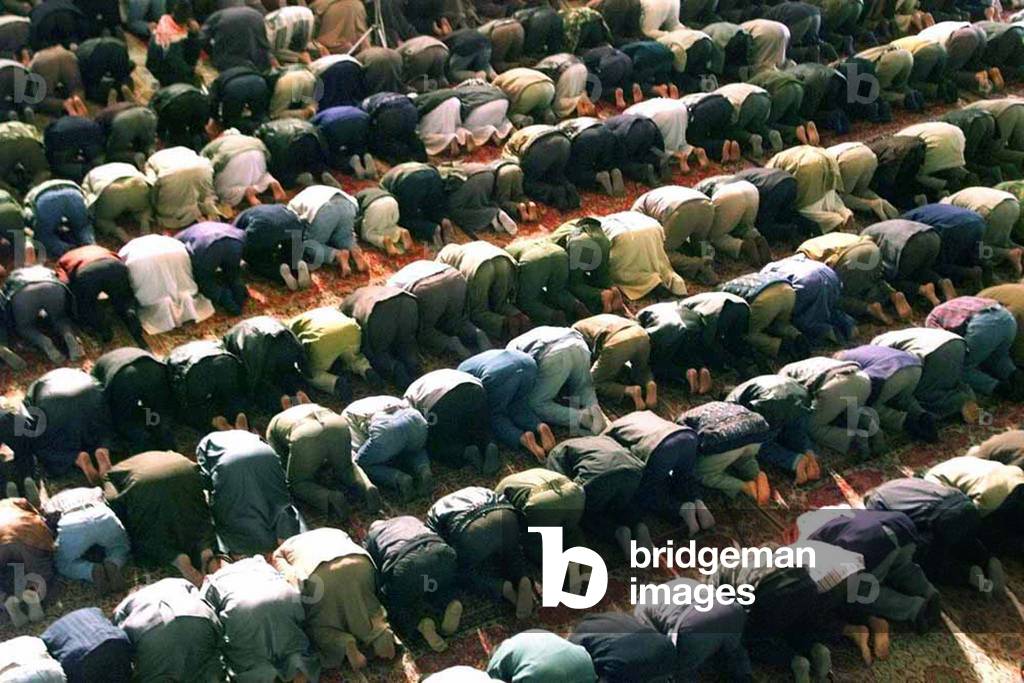 Image of Iraqi men pray at the 14 Ramadan mosque on December