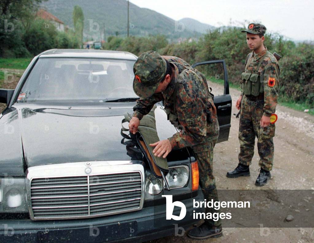 Image of MEMBER OF KOSOVO LIBERATION ARMY PUTS HIS RIFLE IN RIFLE