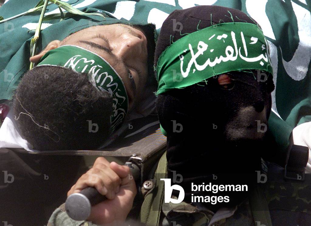 Image of MASKED HAMAS MEMBERS CARRY BODY OF SLAIN PALESTINIAN DURING ...