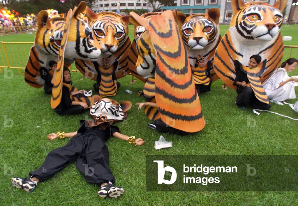 Image of SINGAPOREANS DRESSED AS TIGERS REST BEFORE THE ANNUAL CHINESE NEW