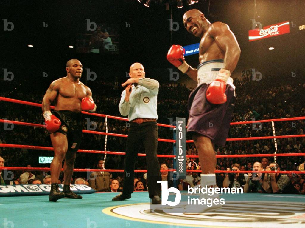 Image of HOLYFIELD GRIMACES AFTER HIS EAR WAS BIT BY TYSON IN