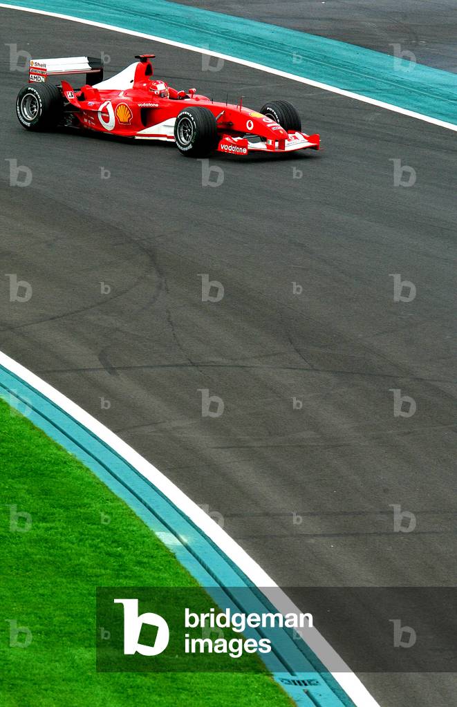 Image of GERMAN FERRARI DRIVER MICHAEL SCHUMACHER TAKES A CURVE DURING A