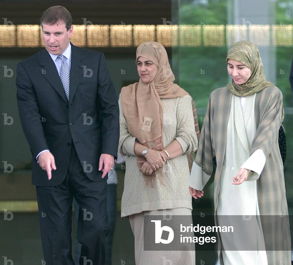 Image of BRITISH PRINCE ANDREW GESTURES AS HE WALKS WITH WOMEN IN