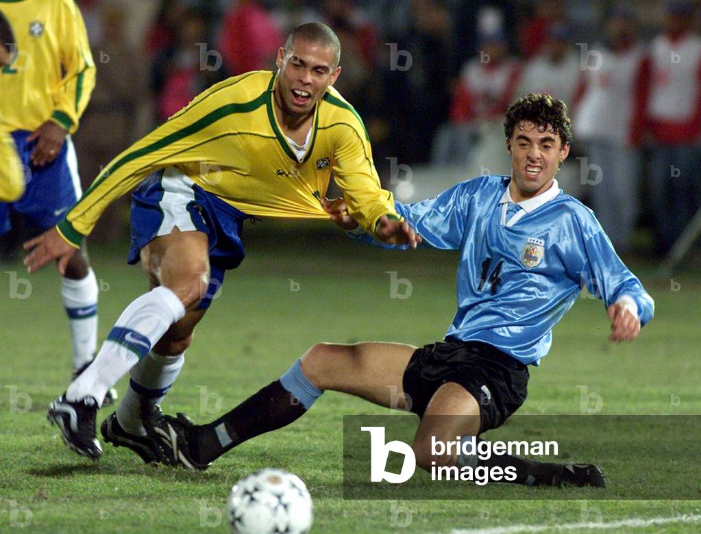 Image of Ronaldo (L) of the Brazilian national soccer team is pulled