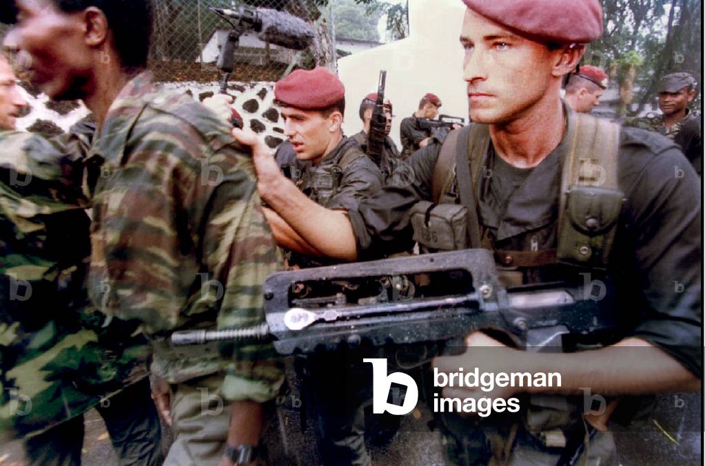 Image of French paratroopers lead away one of some 350 rebel Comorian
