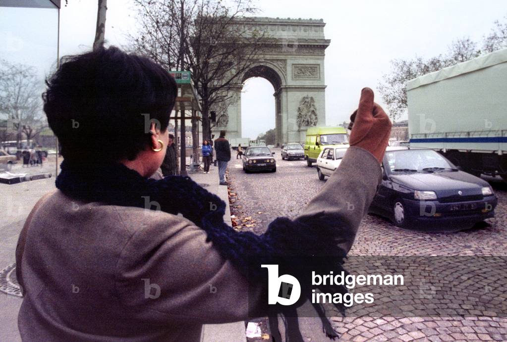 Image of A Parisian commuter tries hitching a lift from passing cars
