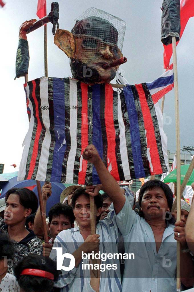 Image of Filipino squatters carry an effigy of Philippine president ...