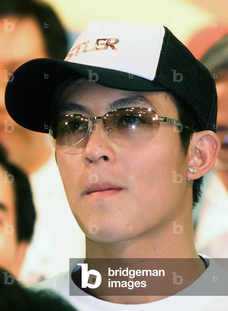 Image of POP SINGER EDISON CHAN LOOKS ON IN HONG KONG, 2002-07-03