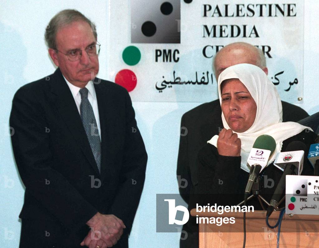 Image of FORMER U.S. SENATOR GEORGE MITCHELL LISTENS TO A PALESTINIAN WOMAN