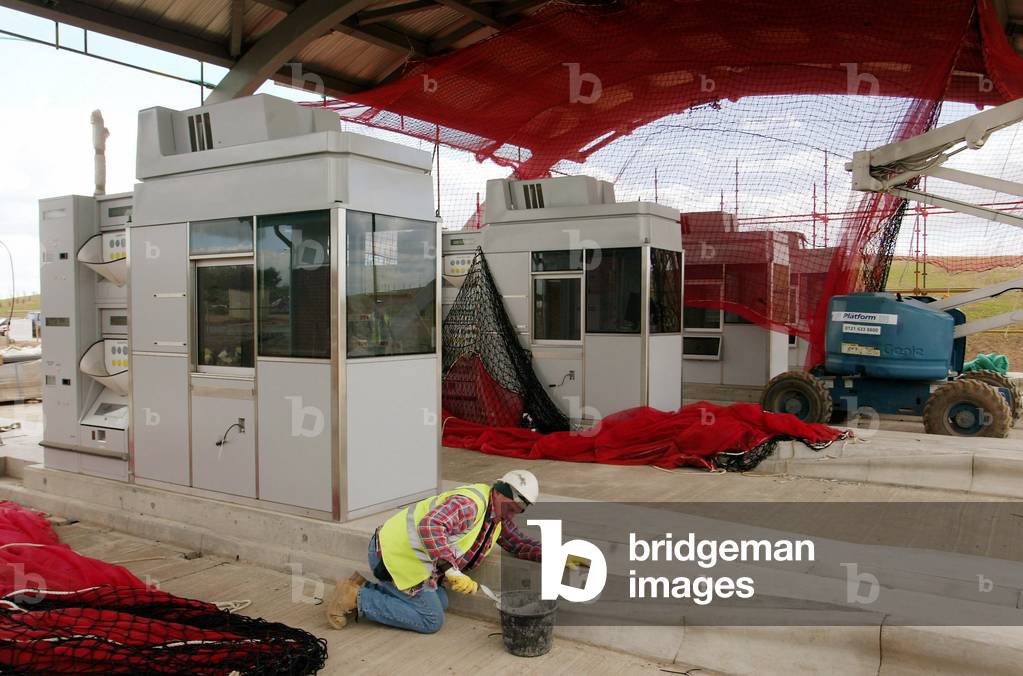Image of A CONSTRUCTION WORKER PUTS THE FINISHING TOUCHES TO A TOLL