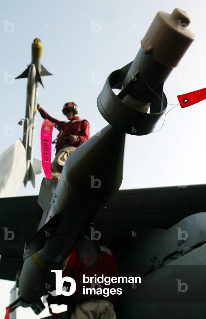 Image of AVIATION ORDINANCEMEN LOAD BOMBS AND MISSILES ON A FIGHTER JET