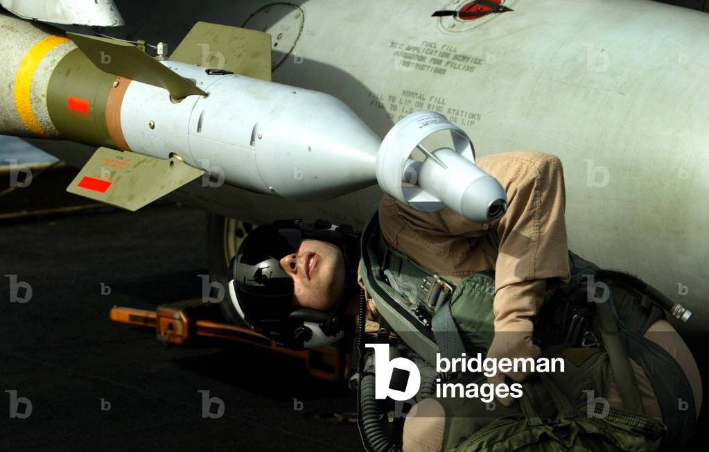 Image of AN F/A-18 HORNET PILOT CHECKS HIS LASER GUIDED BOMBS THE