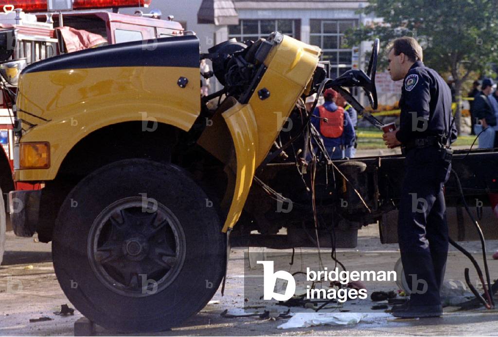 Image of A police officer looks over the wreckage of a school