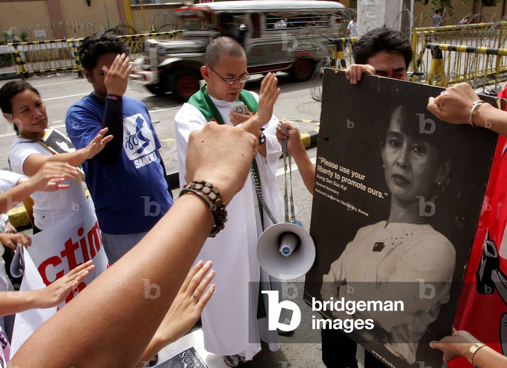 Image of Filipino priest Reyes conducts holy mass next to portrait of