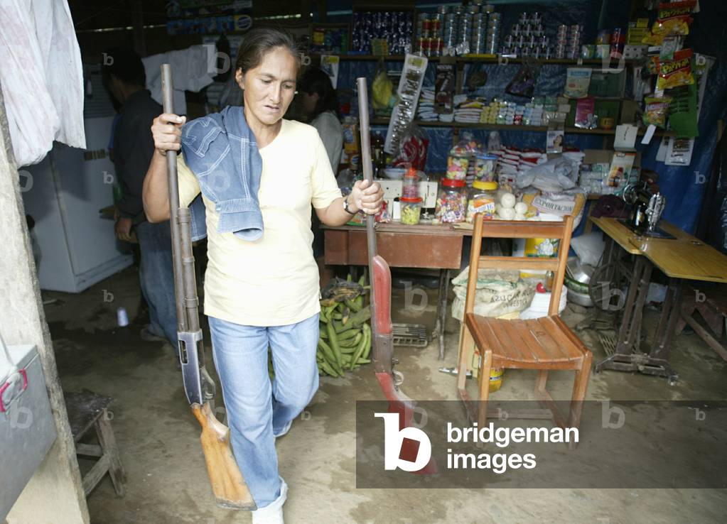 Image of PERUVIAN MARIA QUISEPE DISPLAYS OLD GUNS KEPT BY VILLAGERS IN
