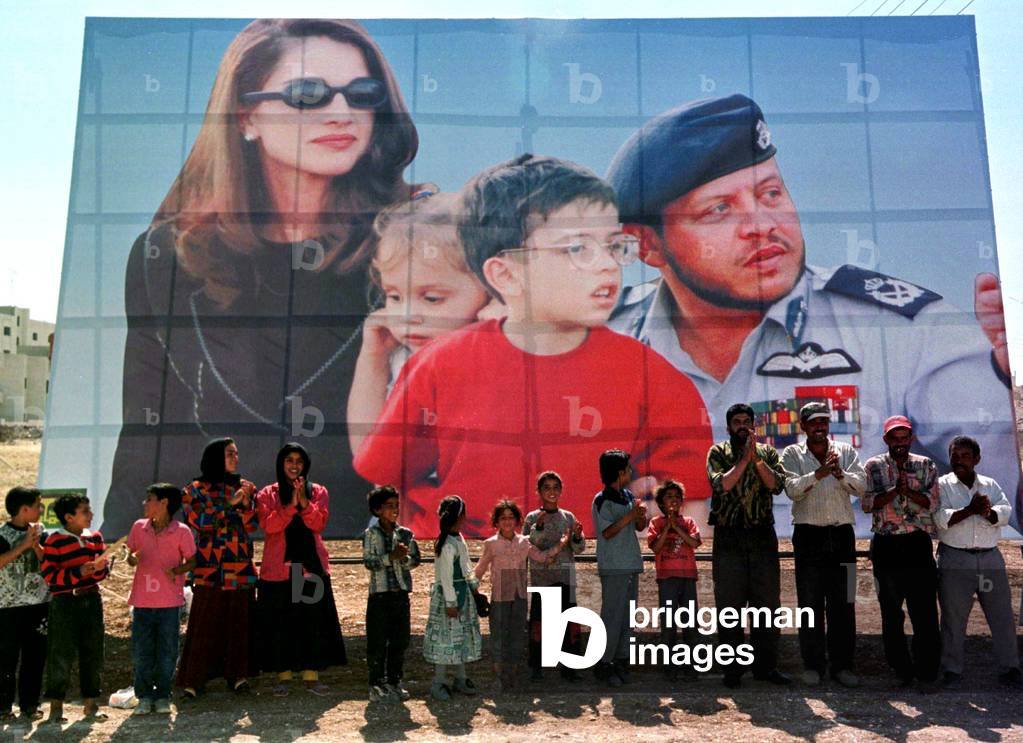 Image of Jordanians celebrate in front of a huge poster of King