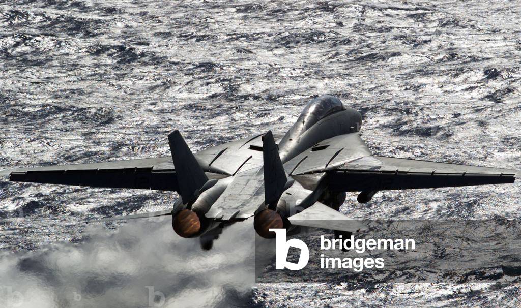 Image of An F-14 Tomcat fighter takes off from the flight deck
