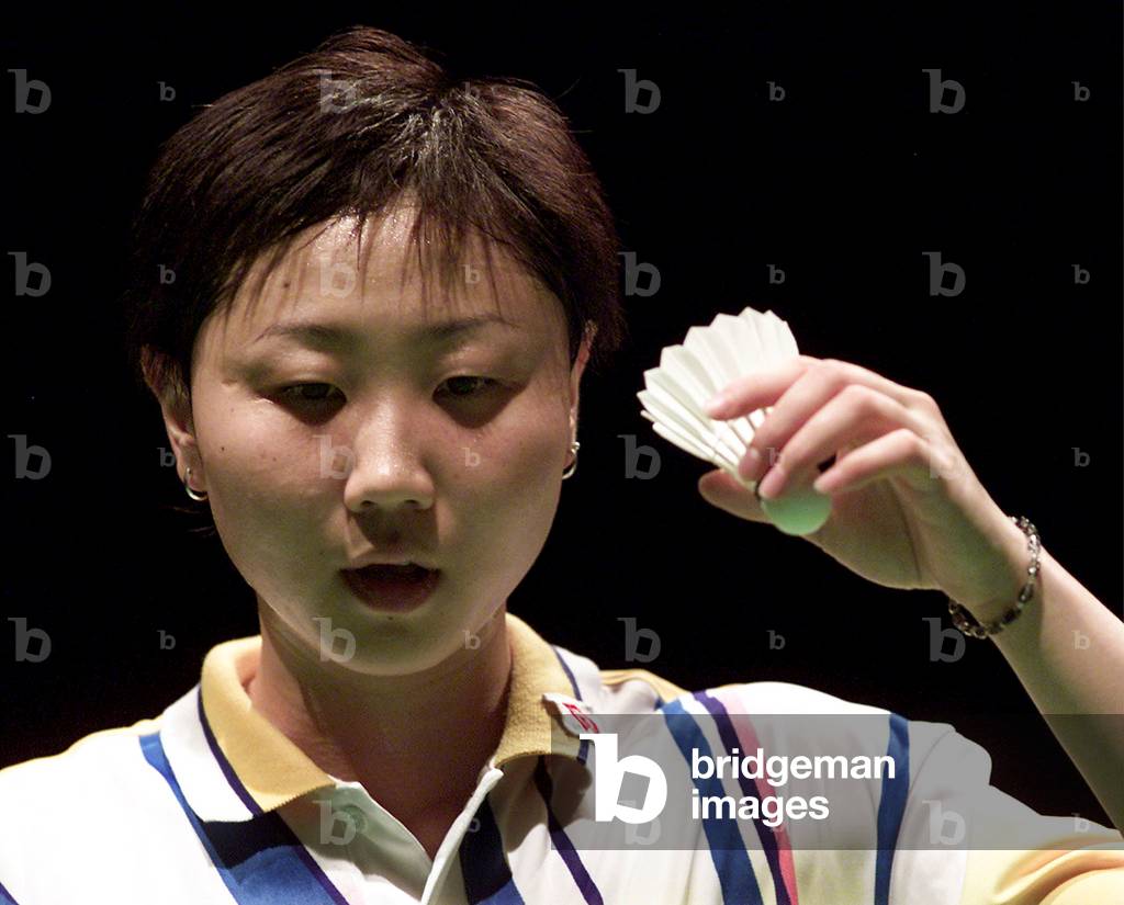Image of CHINESE BADMINTON PLAYER MI ZHOU PREPARES TO SERVE THE SHUTTLE
