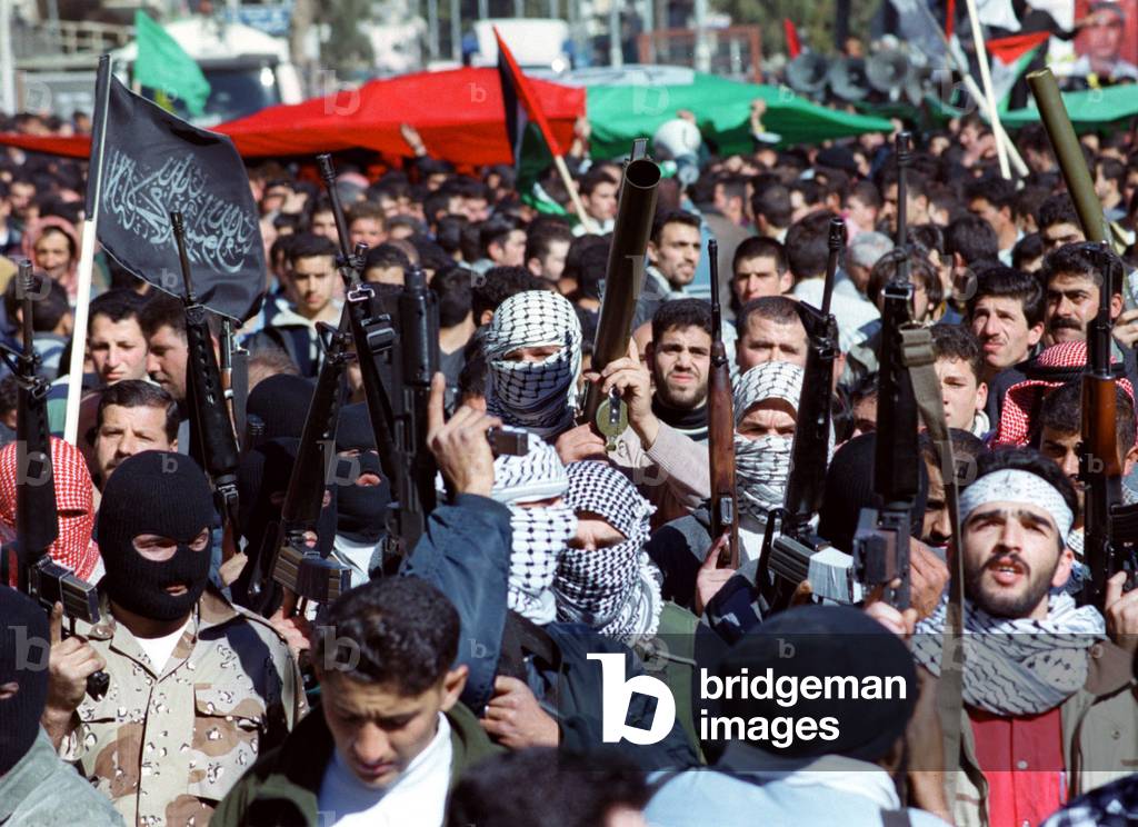 Image of A group of armed Palestinian "Tanzim" fighters march during the