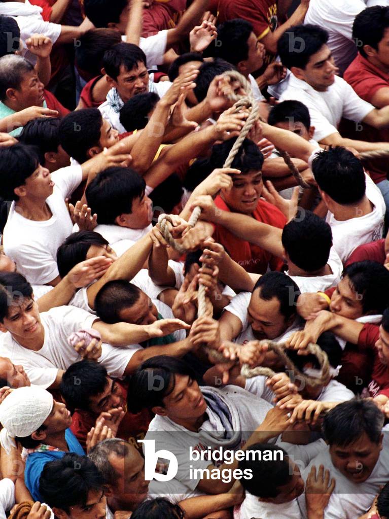 Image of FILIPINO DEVOTEES SCRAMBLE TO HOLD THE ROPE WHICH PULLS THE