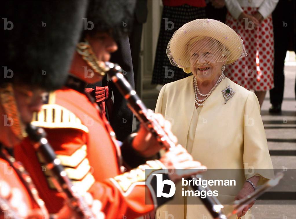 Image of The Queen Mother smiles as the Welsh Guards play happy