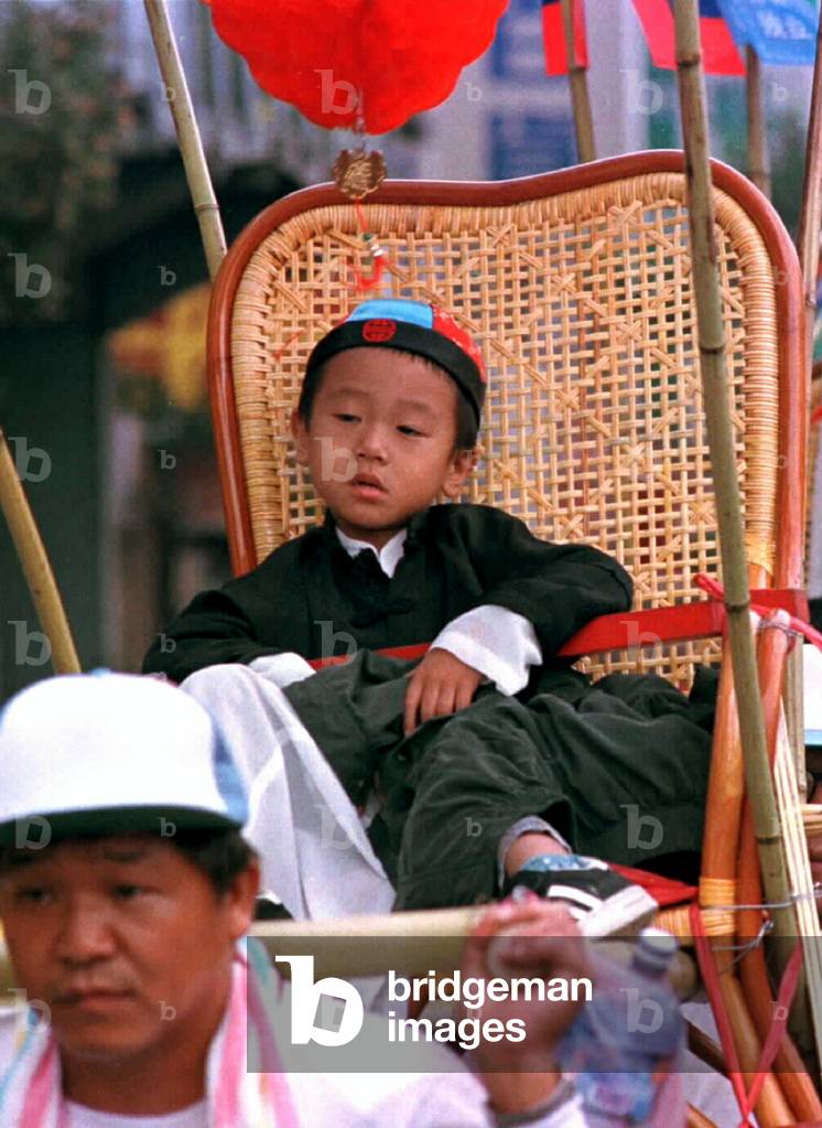 Image of A Taiwanese boy is carried on sedan chairs during a