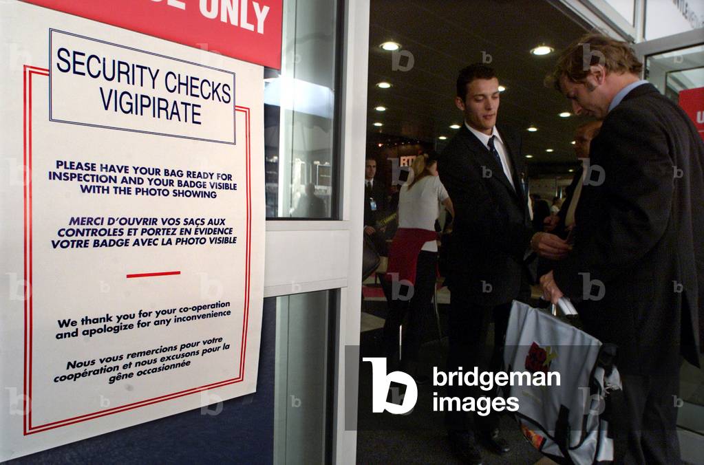 Image of A security guard checks a visitor's badge at the entrance