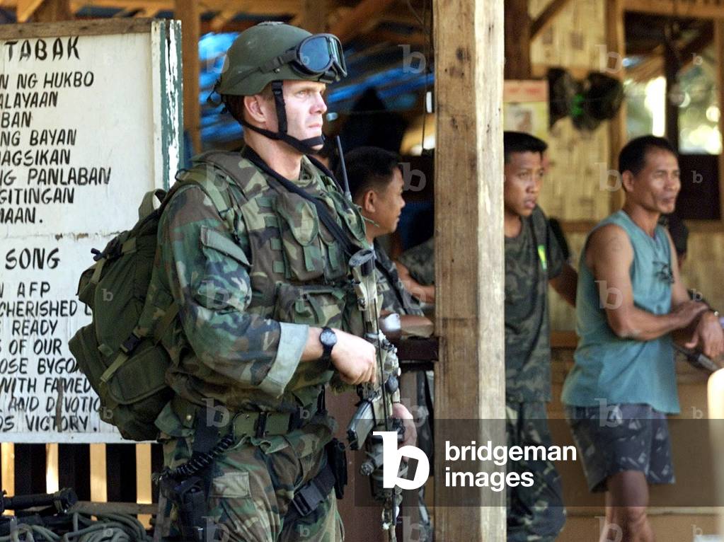 Image of A U.S. soldier stands guard inside the Philippine Army's 103rd