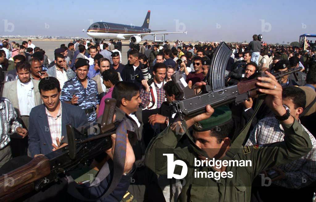 Image of Armed Palestinian police raise their AK-47 assault rifles in the