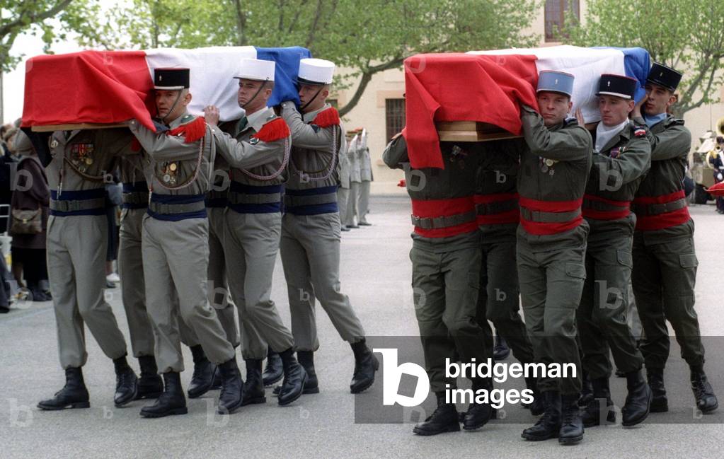 Image of Soldiers carry the flag-draped caskets of the two French soldiers