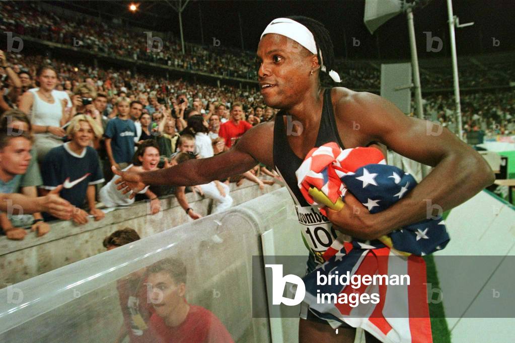 Image of Carl Lewis of the U.S. waves after he had ran