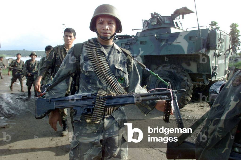 Image of PHILIPPINE GOVERNMENT SOLDIERS PASS AN ARMOURED VEHICLE UPON ...