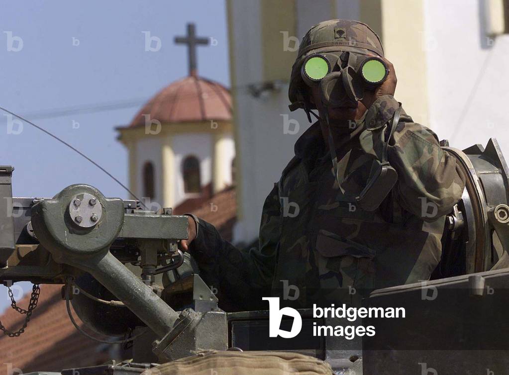 Image of A U.S. SOLDIER GUARDS AN ORTHODOX CHURCH IN THE VILLAGE