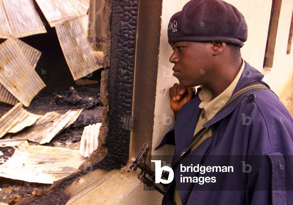 Image of UGANDAN SOLDIER LOOKS INSIDE PRAYER HOUSE IN KANUNGU AFTER MASS