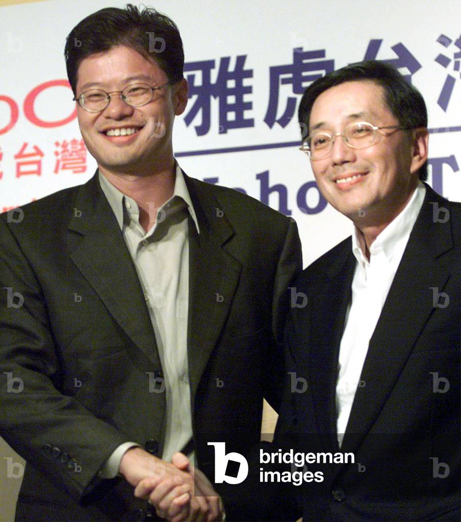 Image of Yahoo! co-founder Jerry Yang (L) shakes hands with T.J. Huang,