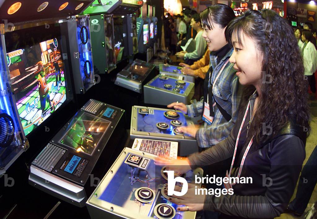 Image of Young Japanese women punch computer buttons in rhythm as they