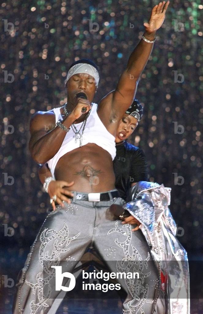 Image of Singer Tyrese dances as he is embraced by singer Da