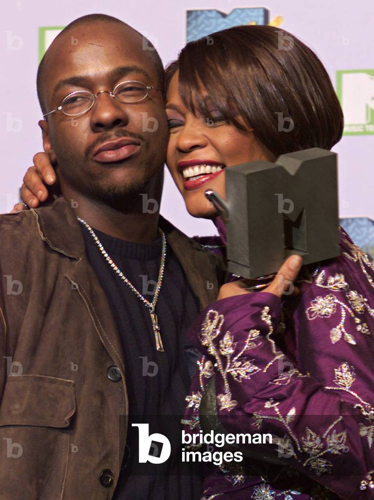 Image of Whitney Houston (R) hugs her husband Bobby Brown after recieving
