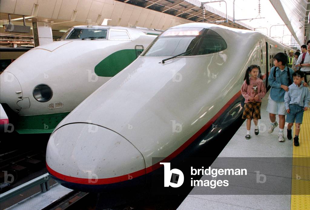 Image of A new bullet train "shinkansen," flanked by an earlier model