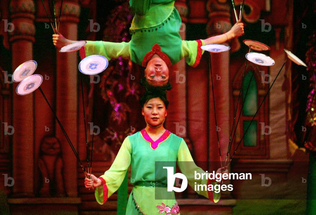 Image of Gao Ning balances her twin sister Gao Ding (top) on