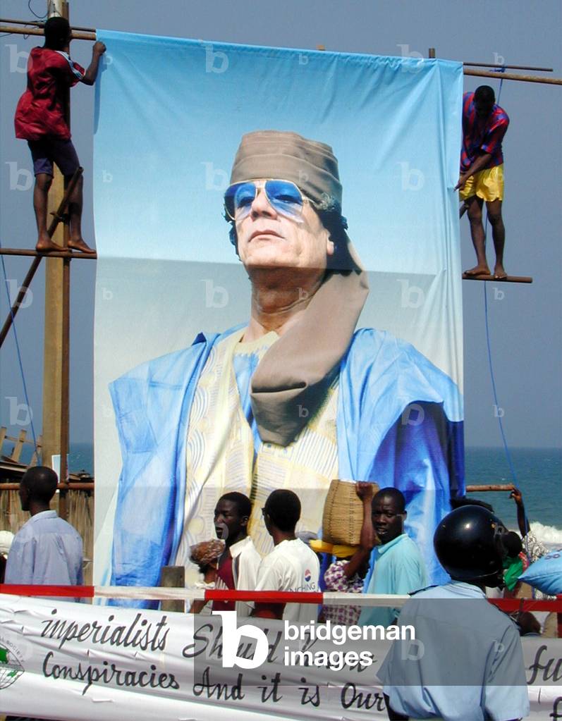 Image of WORKMEN ERECT A BANNER IN HONOUR OF MUAMMAR GADDAFI'S VISIT