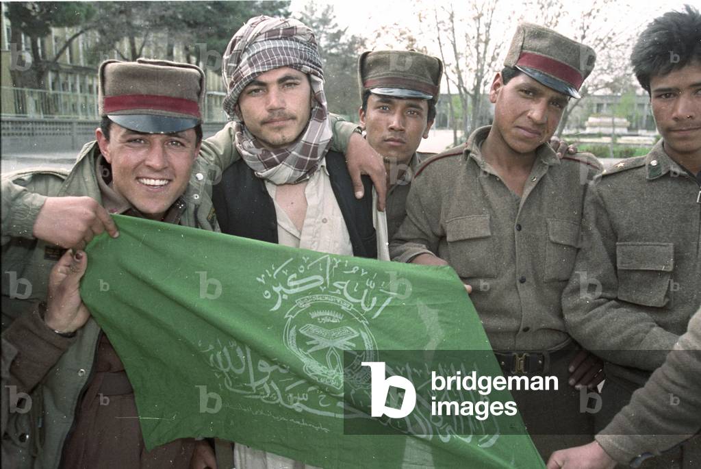Image of A mujahideen troop, joins with government forces while holding an