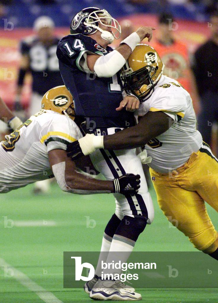 Image of ARGONAUTS QB BELL HIT BY ESKIMOS RESSE AND WILLIAMS IN